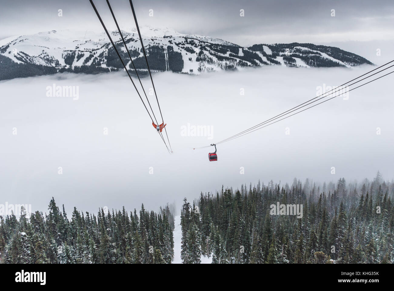 Cable car running between two snow covered mountains at a ski resort ...