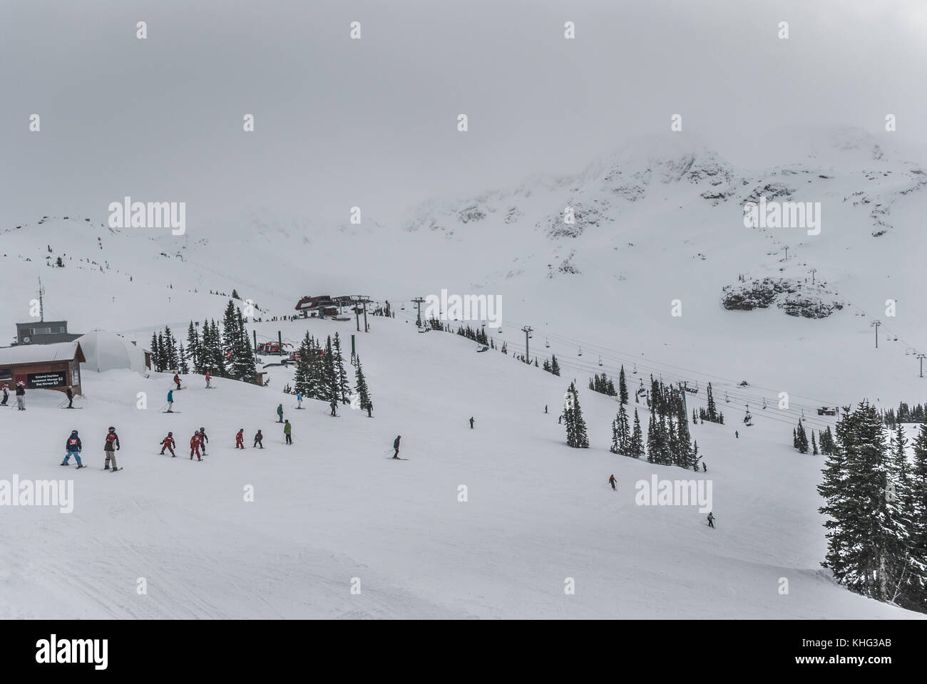 Aerial photo of large group of people skiing and snowboarding from top ...