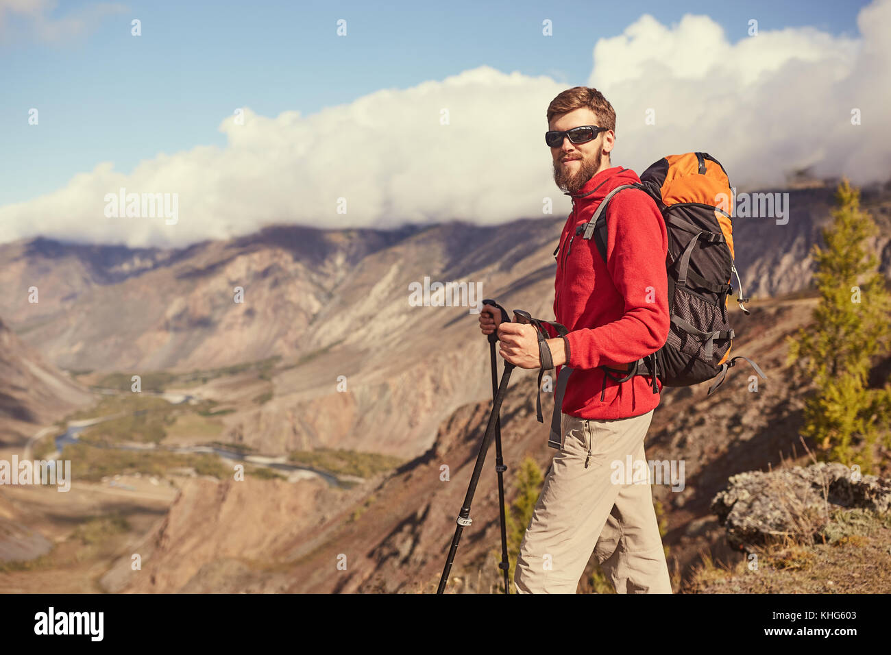 Time for thought. Handsome young bearded male hiker with sunglasses ...