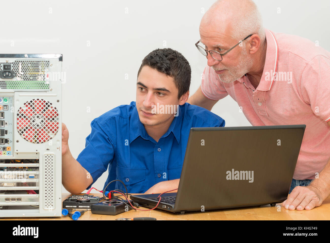 young man and senior fixing computer Stock Photo - Alamy