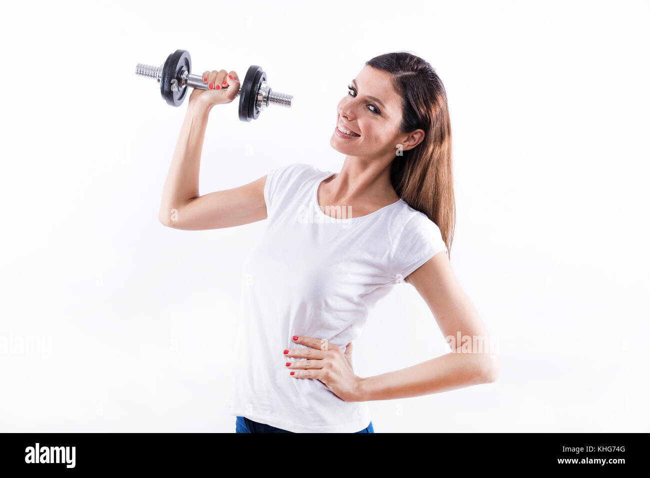 A beautiful young woman lifting weight and smiling Stock Photo - Alamy
