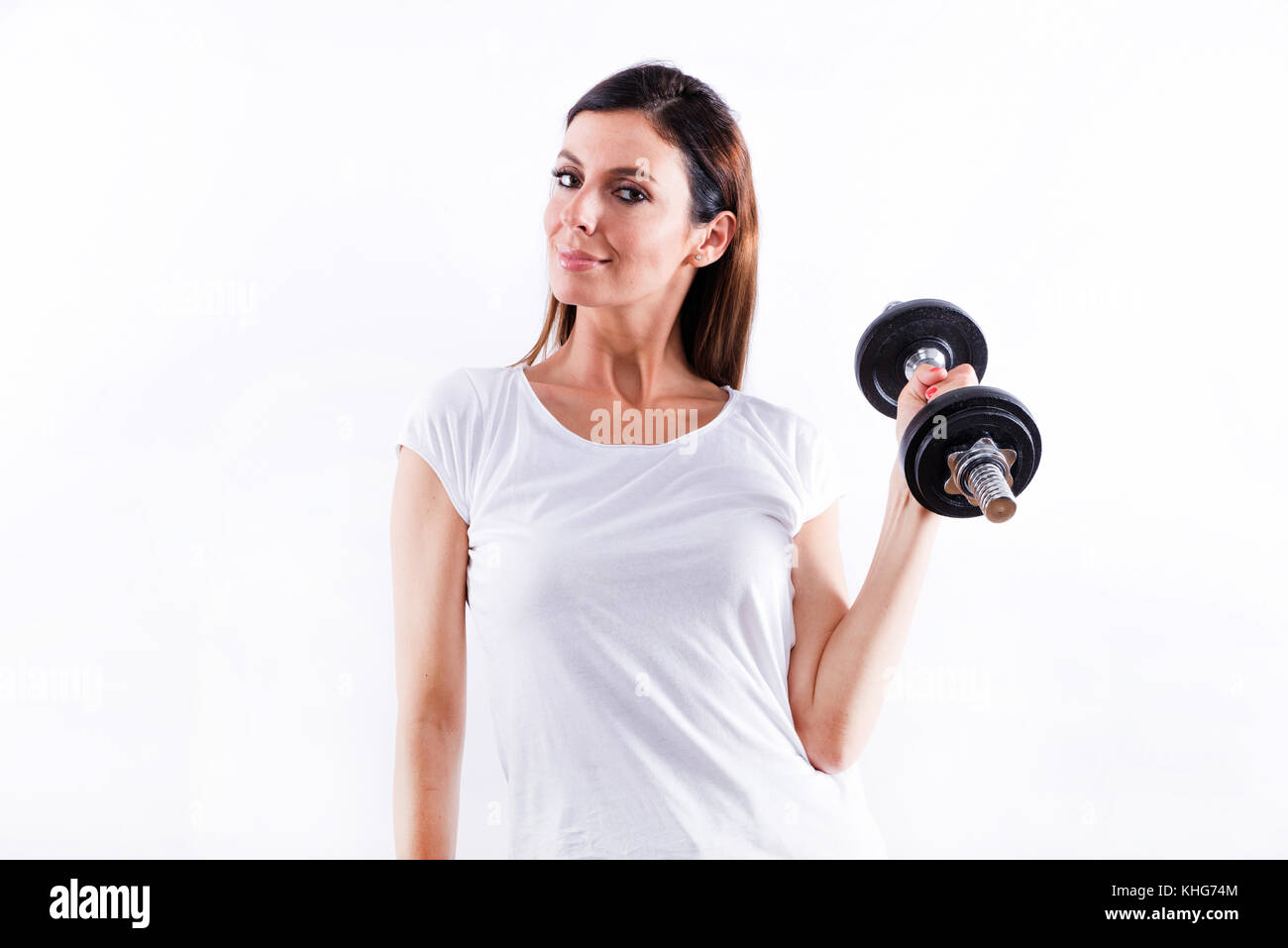 A beautiful young woman lifting weight and smiling Stock Photo - Alamy