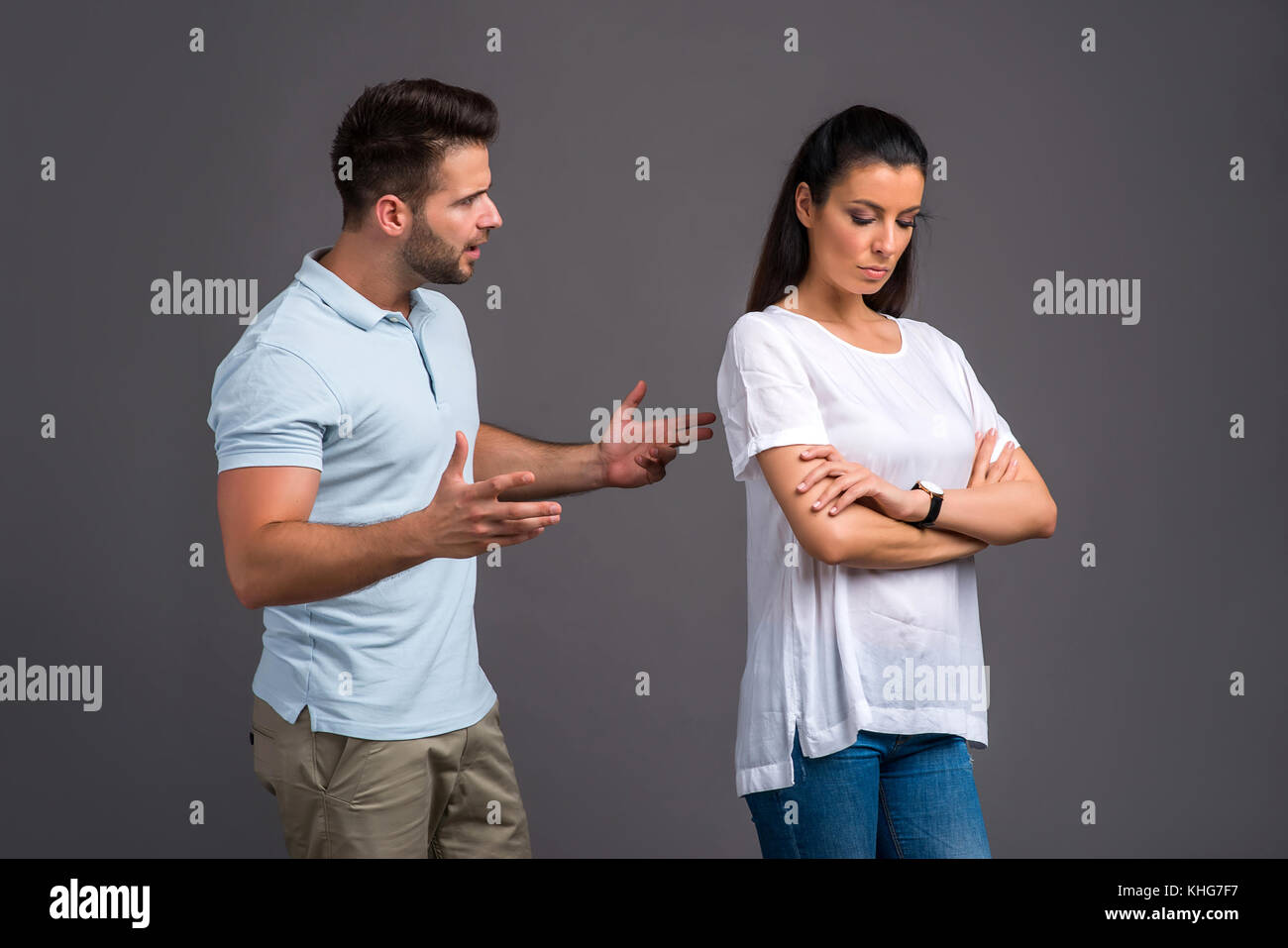 A beautiful young couple standing and arguing in the studio Stock Photo ...
