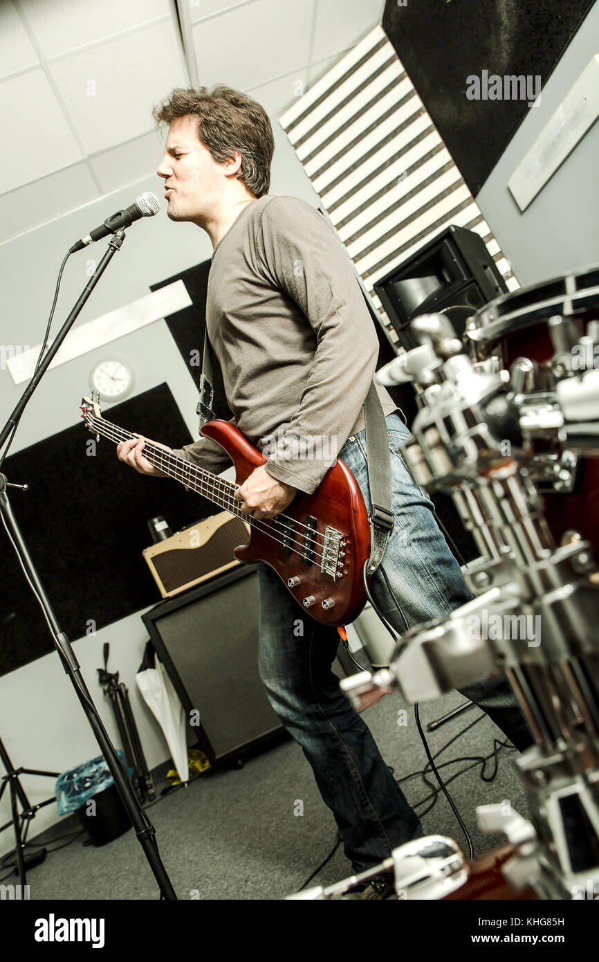 A Rock musician playing passionately bass in the rehearsal Studio Stock ...