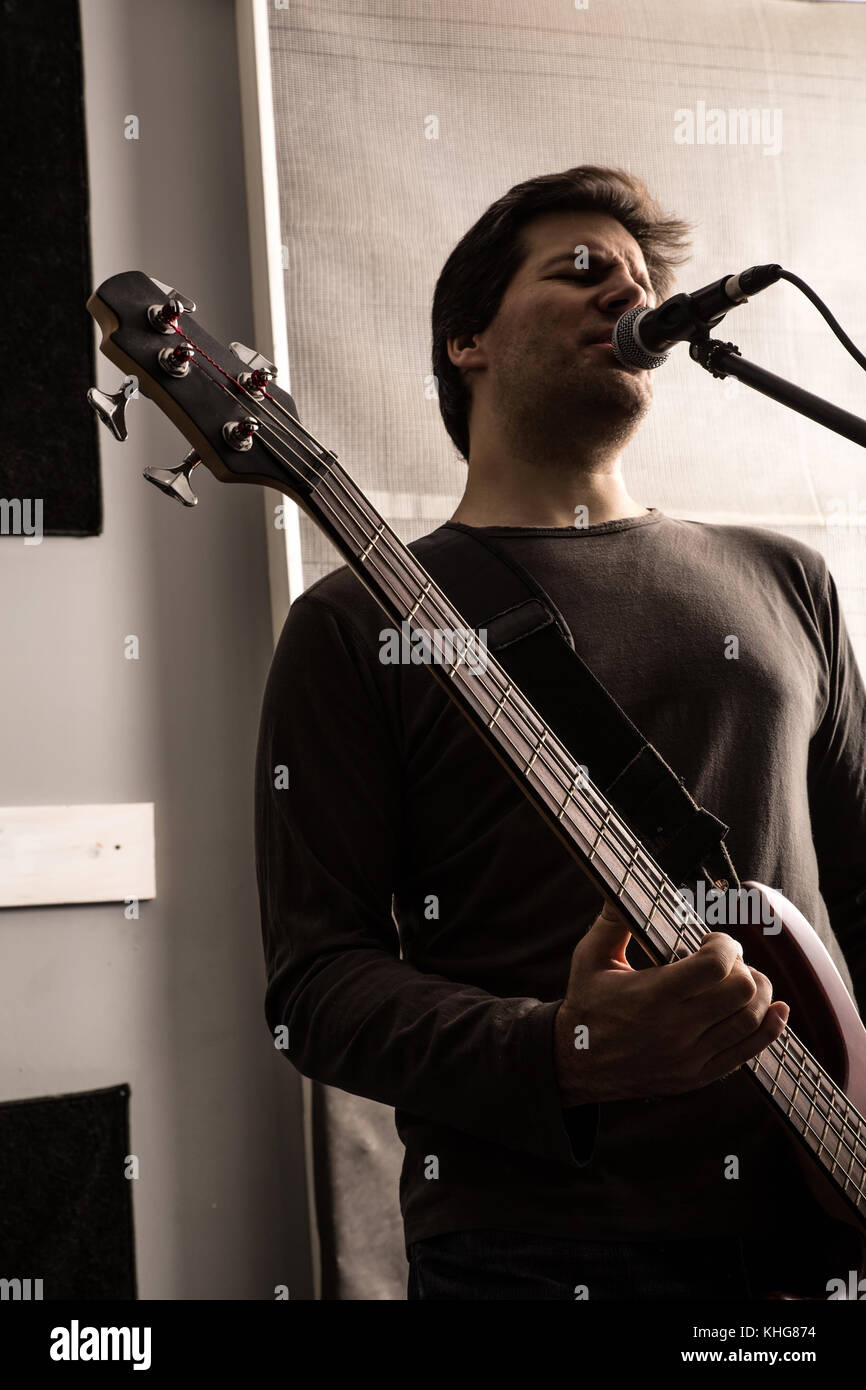 A Rock singer playing bass in the rehearsal Studio Stock Photo - Alamy