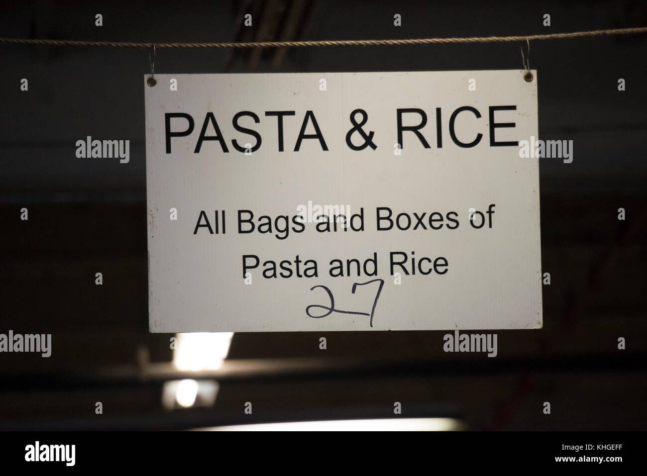Overhead signs help volunteers sort mixed containers of donated foods ...