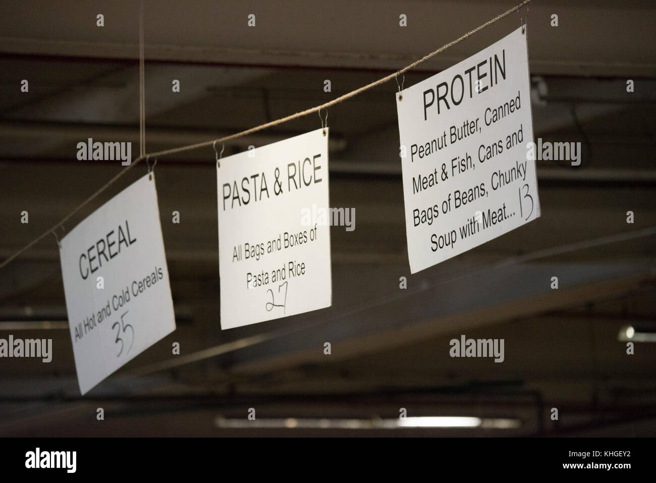 Overhead signs help volunteers sort mixed containers of donated foods ...