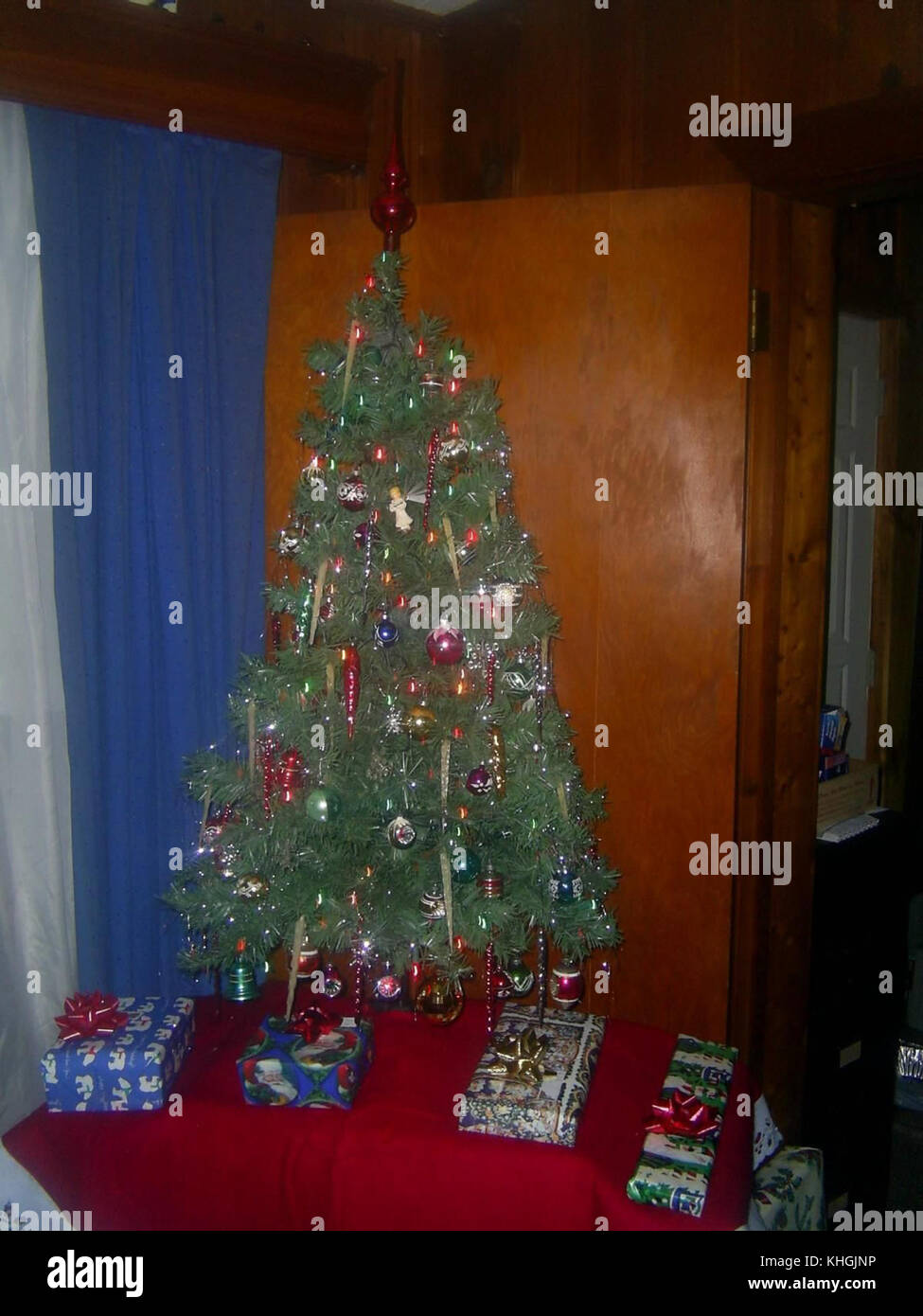 A small artificial Christmas tree with presents Stock Photo - Alamy