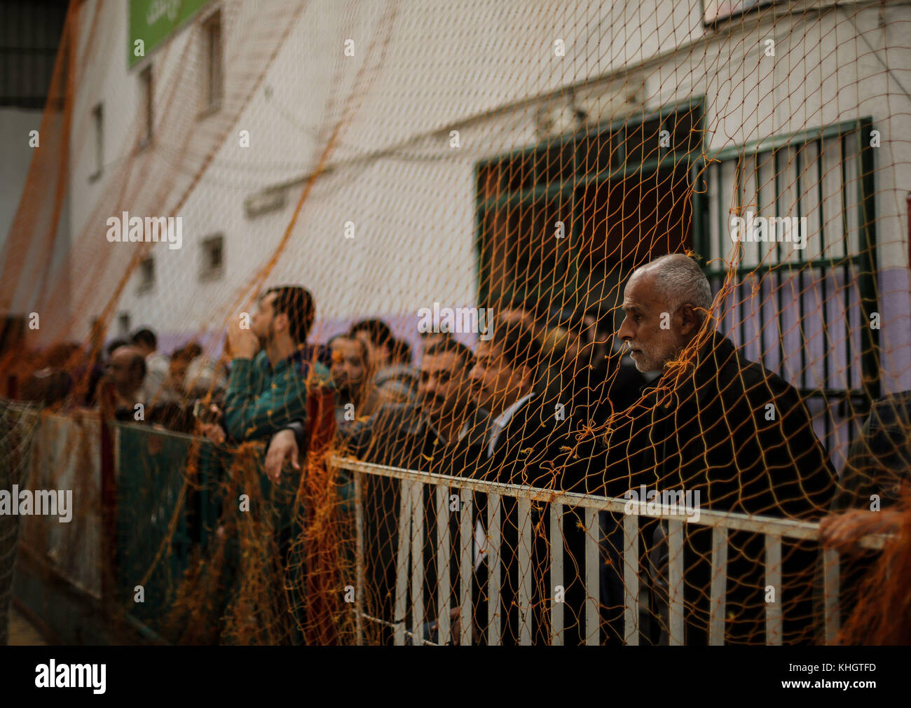 Palestinians gather at a makeshift bus station in a basketball court as ...