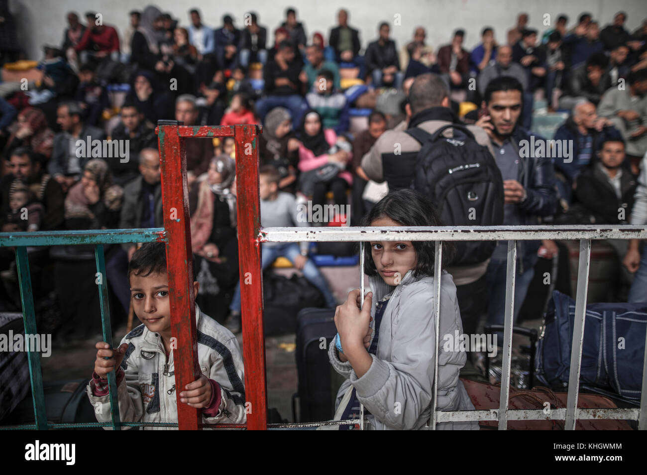 Palestinians gather at a makeshift bus station in a basketball court ...