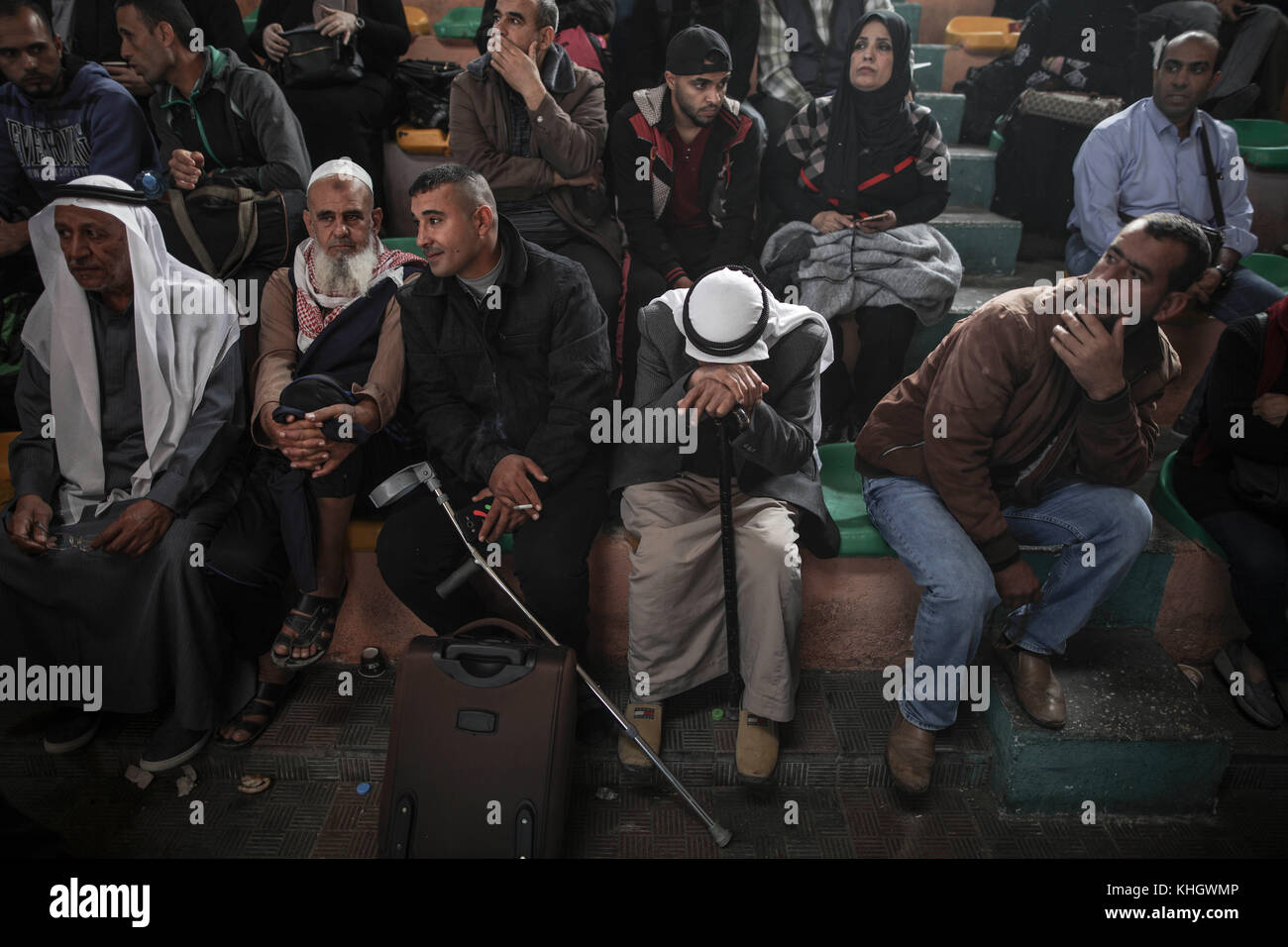 Palestinians gather at a makeshift bus station in a basketball court ...