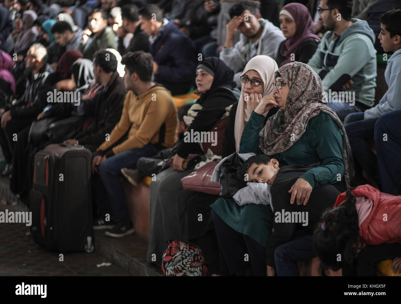 Palestinians gather at a makeshift bus station in a basketball court ...