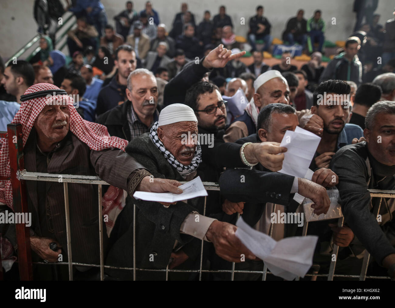 Palestinians gather at a makeshift bus station in a basketball court ...