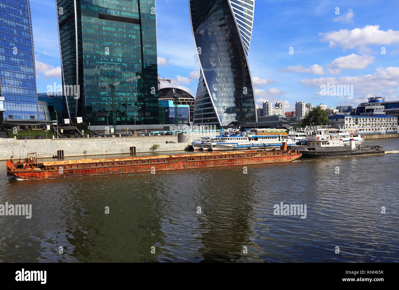 Barge and tugboat on the background of the waterfront and cityscape ...