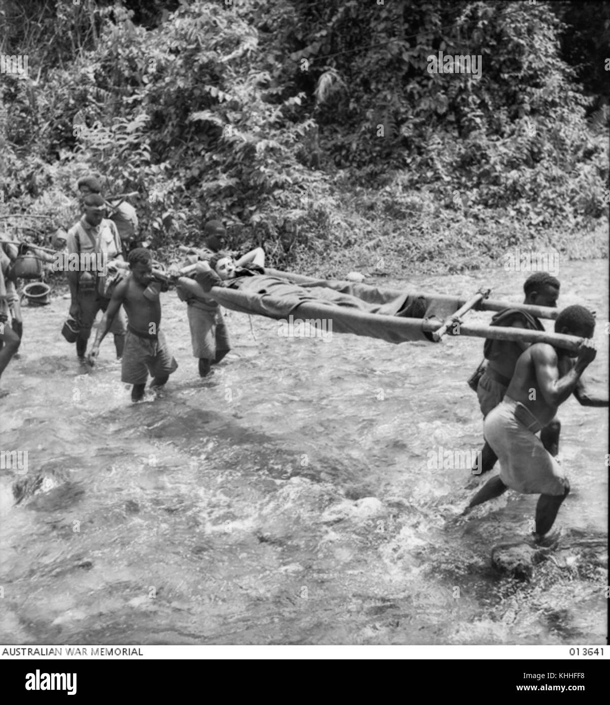 Wounded being brought in by Papuan bearers Stock Photo - Alamy