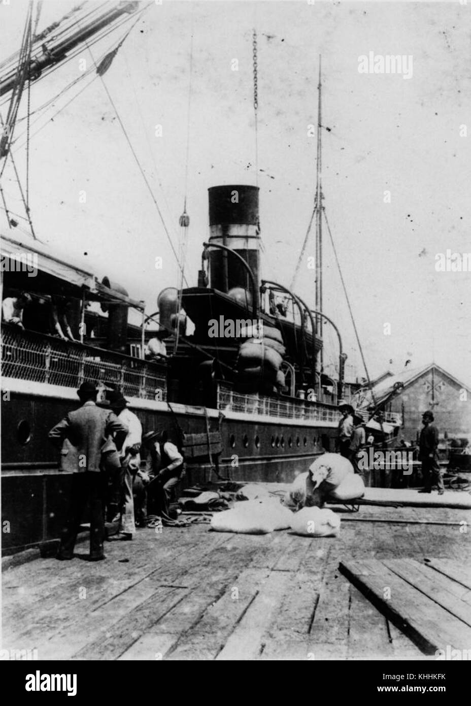 This historical photograph shows the unloading of a ship at an ...