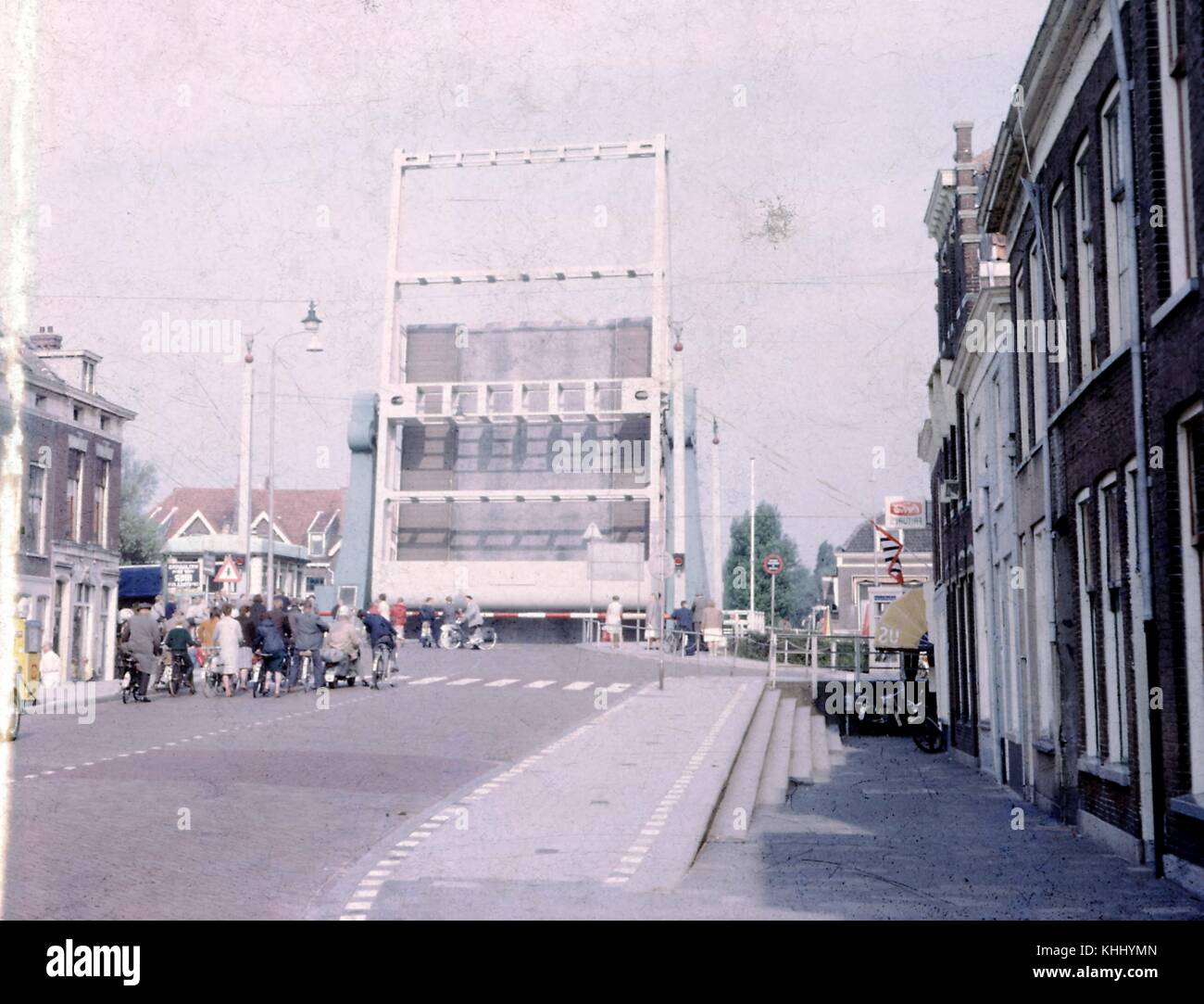 Large group of bicyclists approaching a raised drawbridge on a city ...