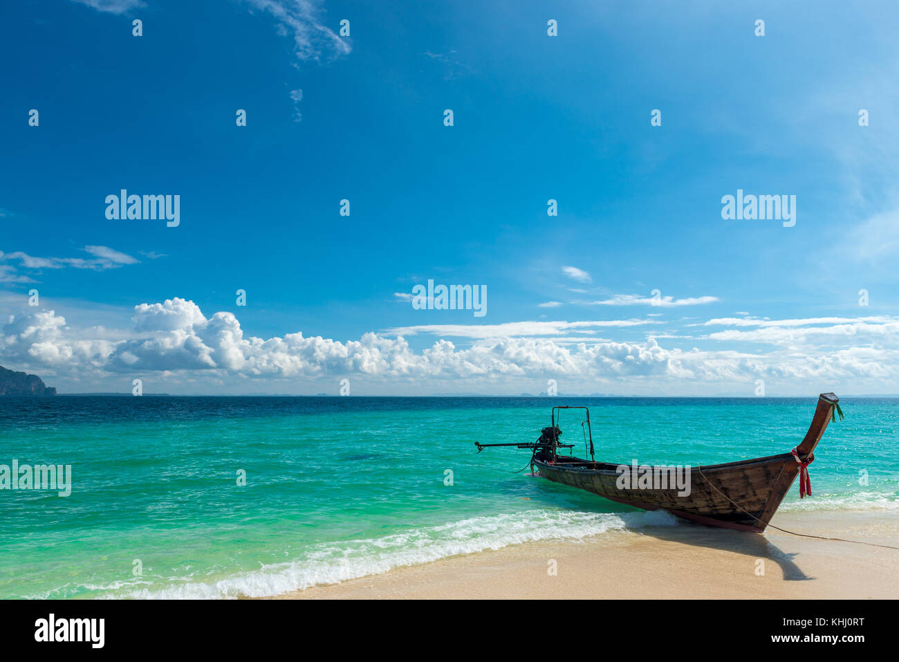 traditional Thai boat long tail near the shore in the turquoise sea ...
