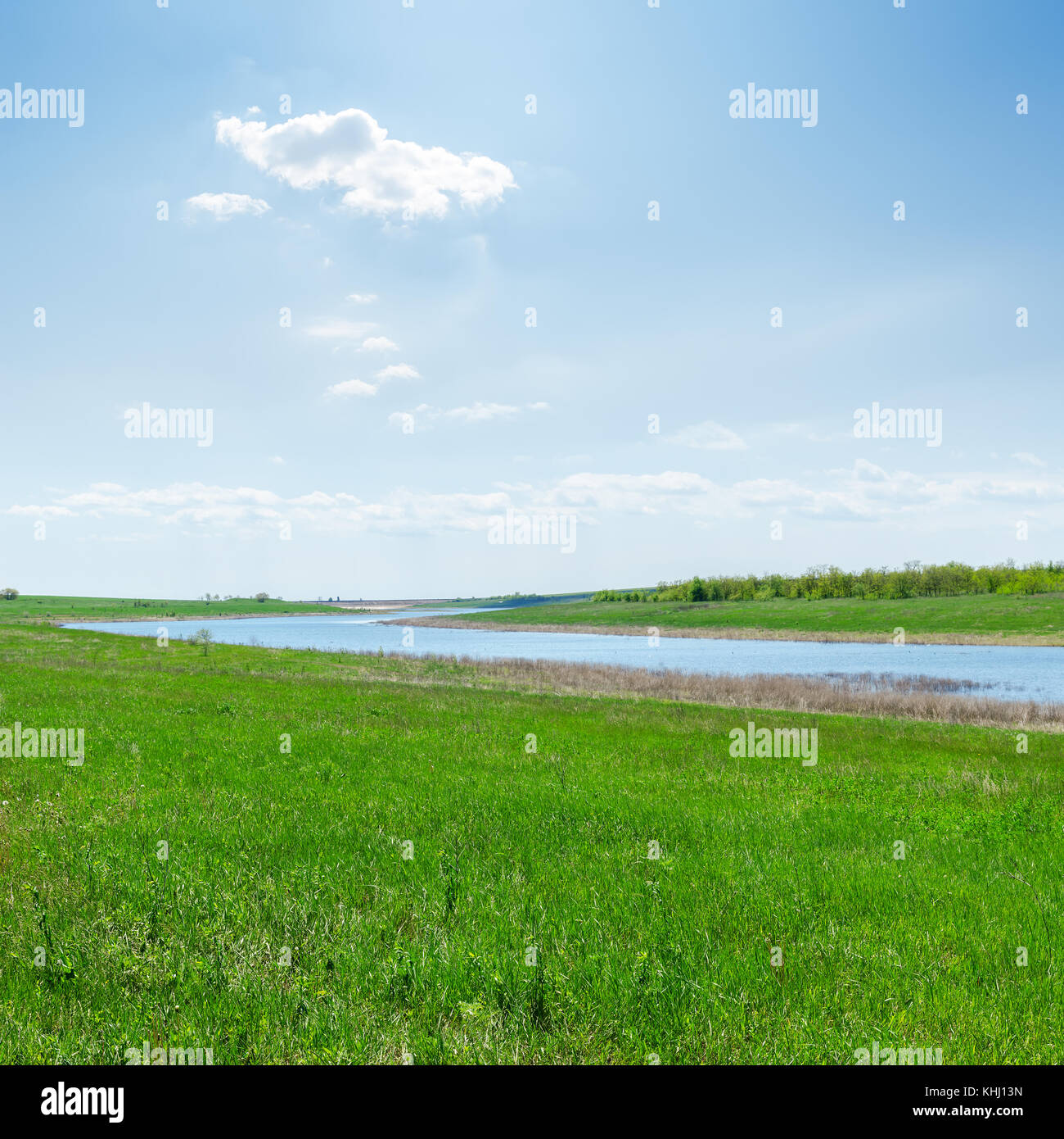 river in green grass and clouds over it Stock Photo - Alamy