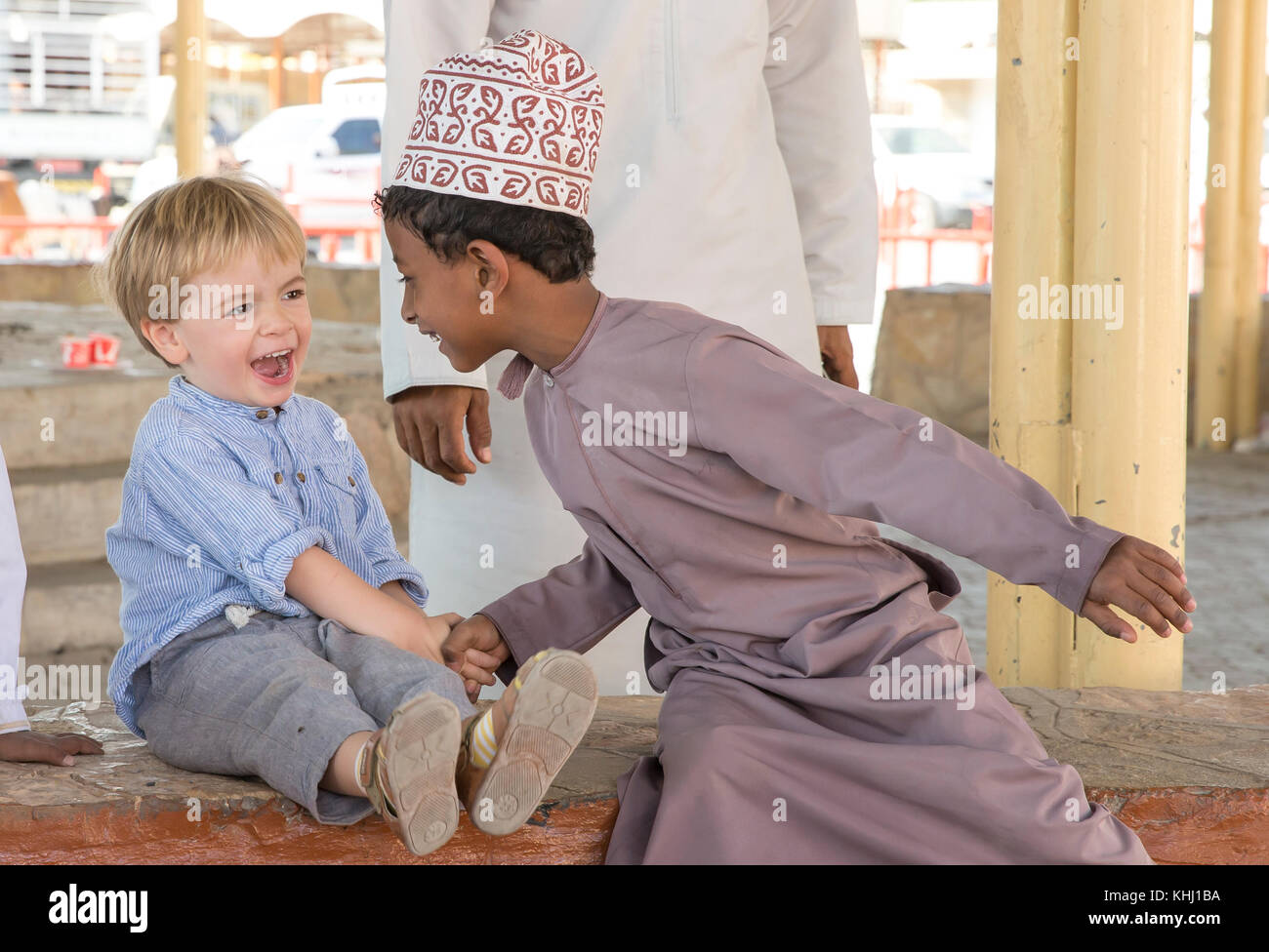 Nizwa, Oman, 10th Nobember 2017: omani kid and european kid giving ...