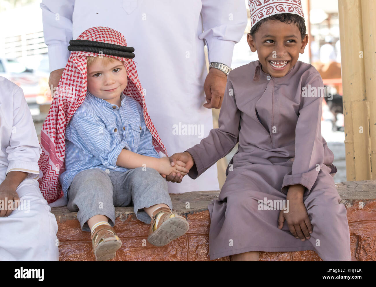 Nizwa, Oman, 10th Nobember 2017: omani kid and european kid shaking ...