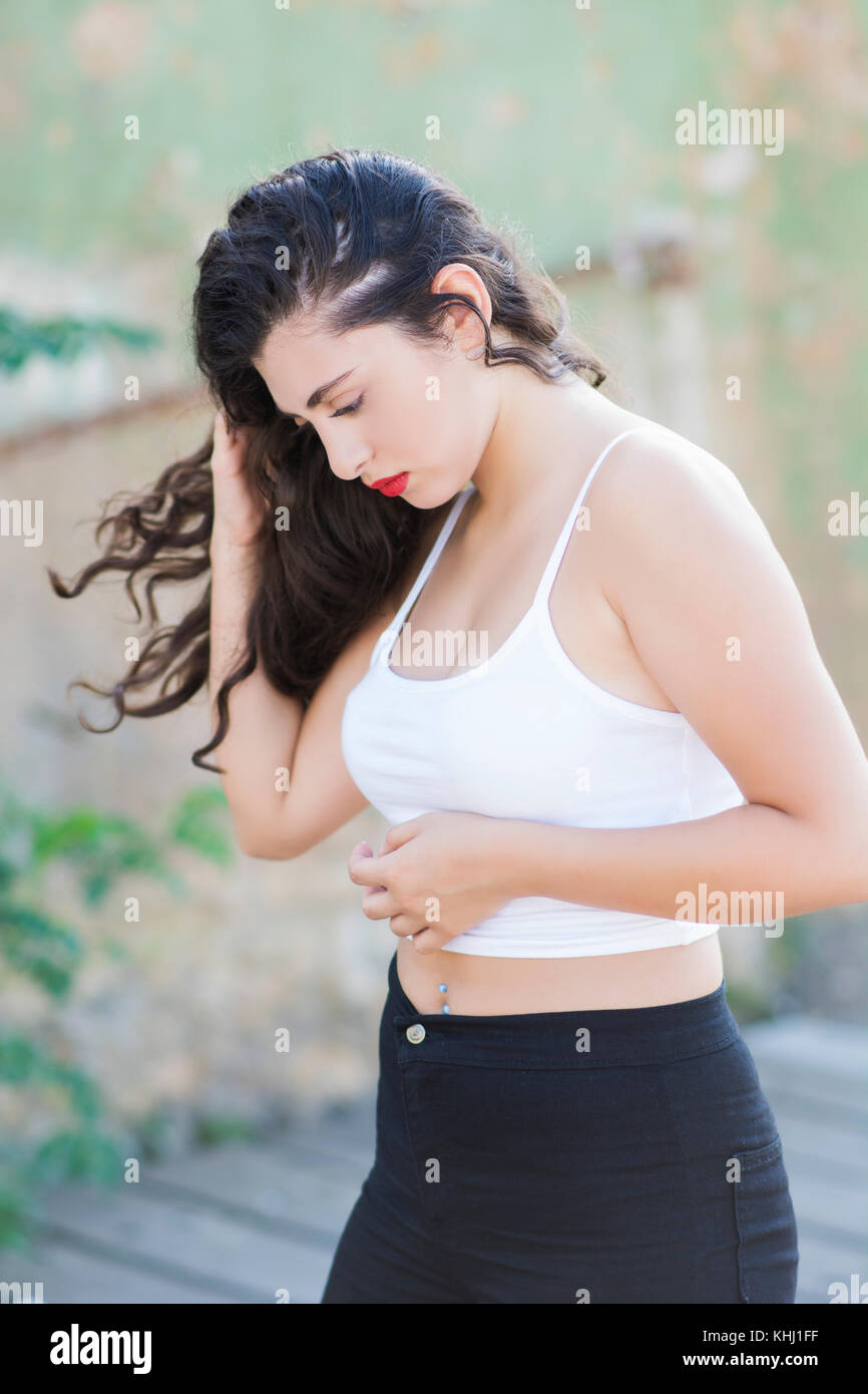 Sad young woman walking outdoors looking down Stock Photo - Alamy