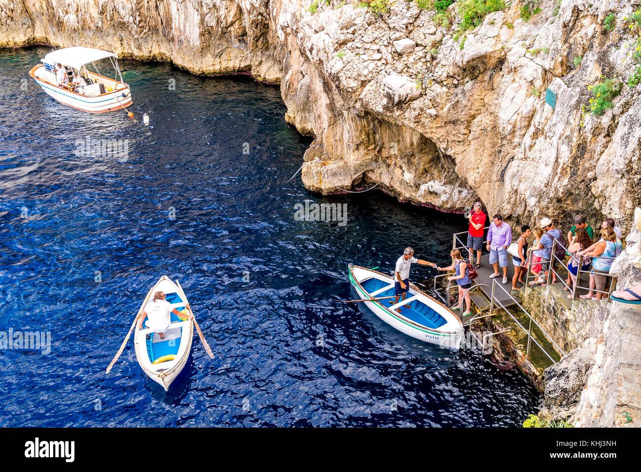 A line of tourists wait for their boat ride into the famous Blue Grotto ...
