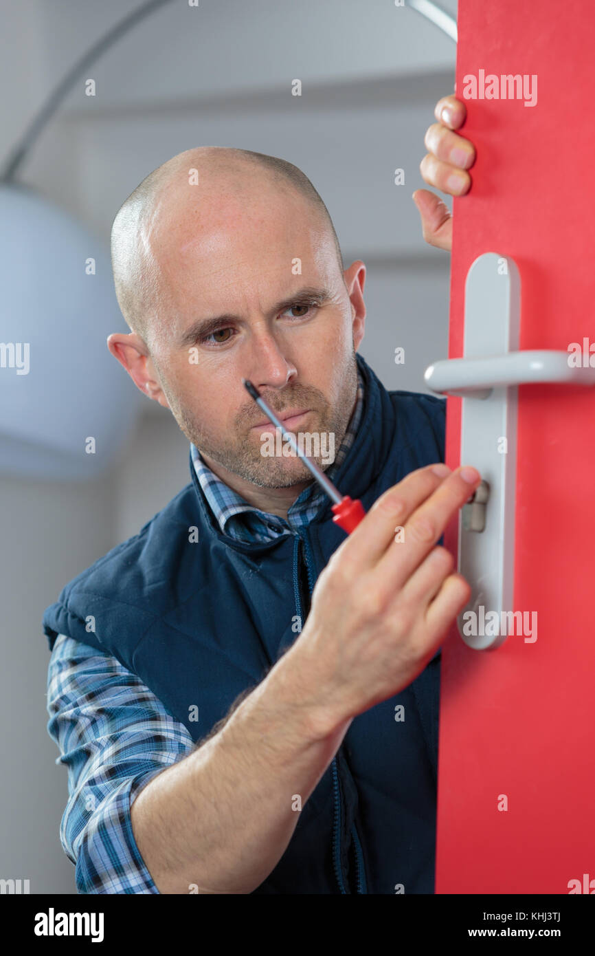man fixing the door with screwdriver Stock Photo - Alamy