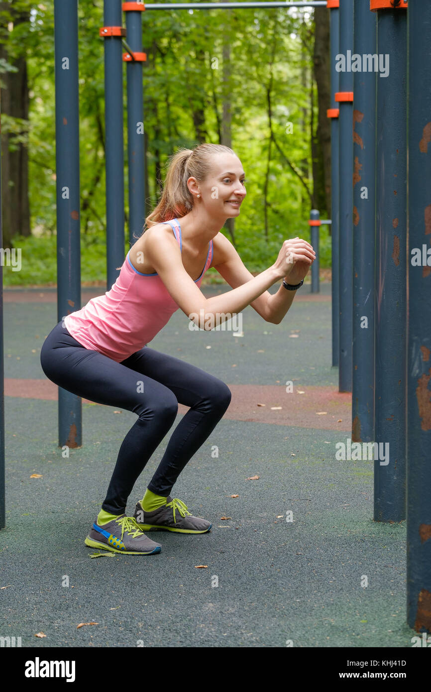 Young slim woman doing workout on training ground Stock Photo - Alamy