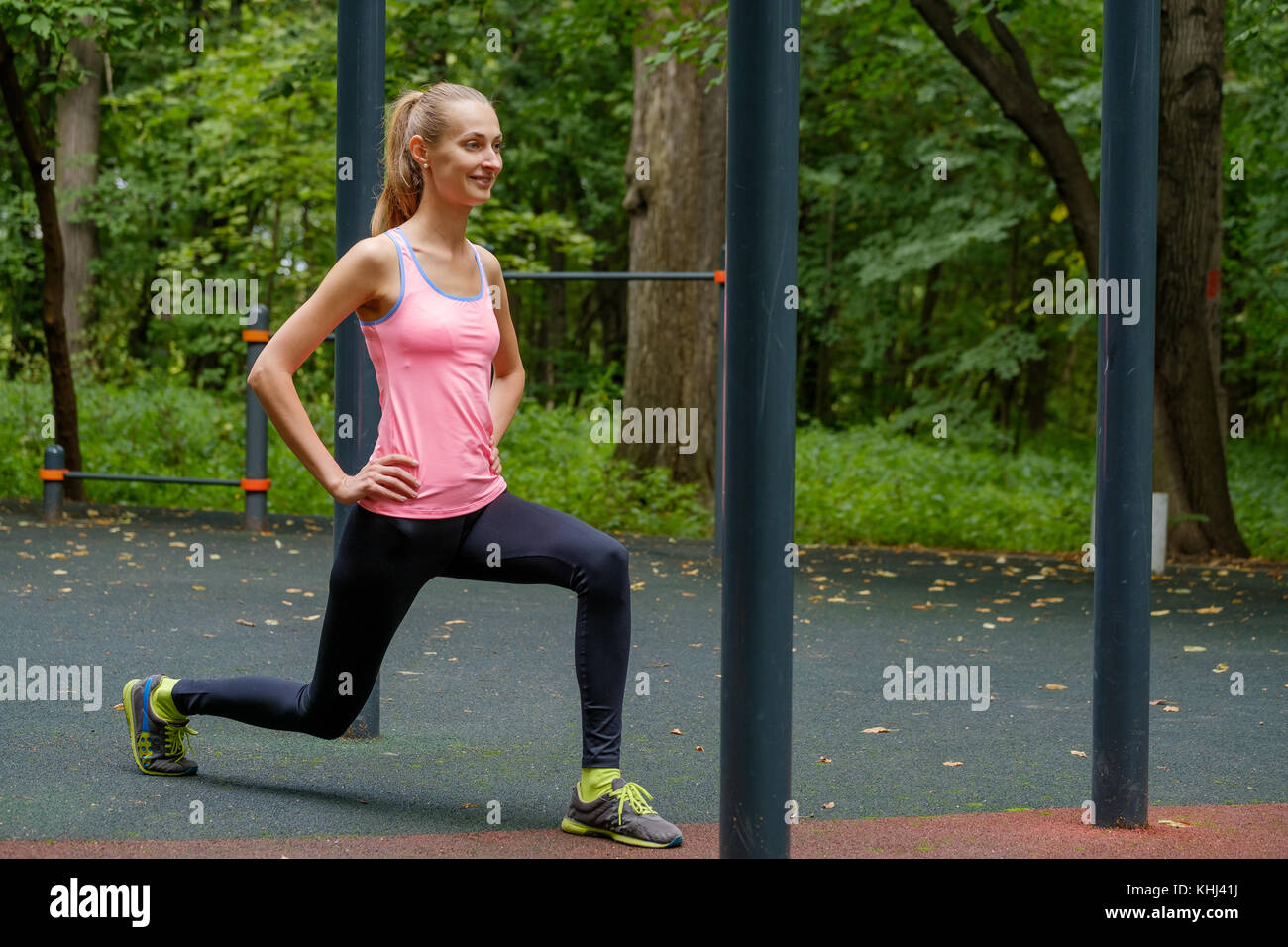 Young slim woman doing workout on training ground Stock Photo - Alamy