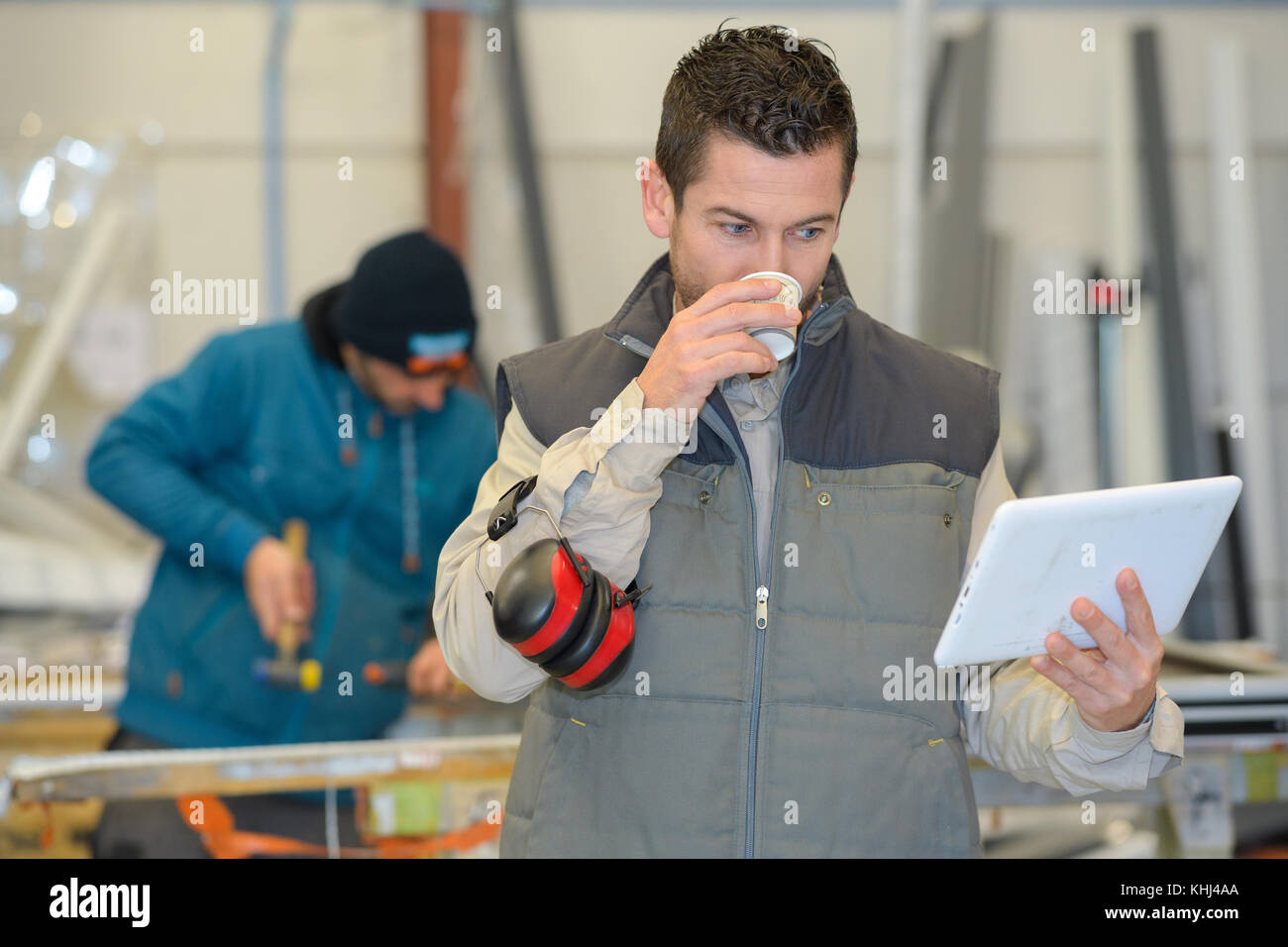 warehouse worker drinking coffee while checking his tablet Stock Photo ...