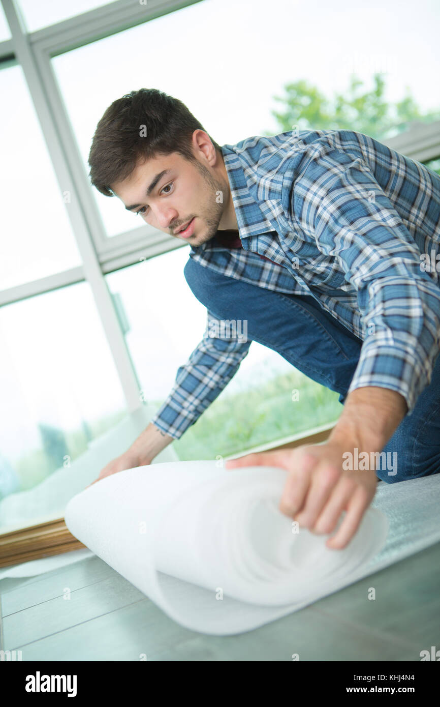 construction worker unrolling foil at building site Stock Photo - Alamy