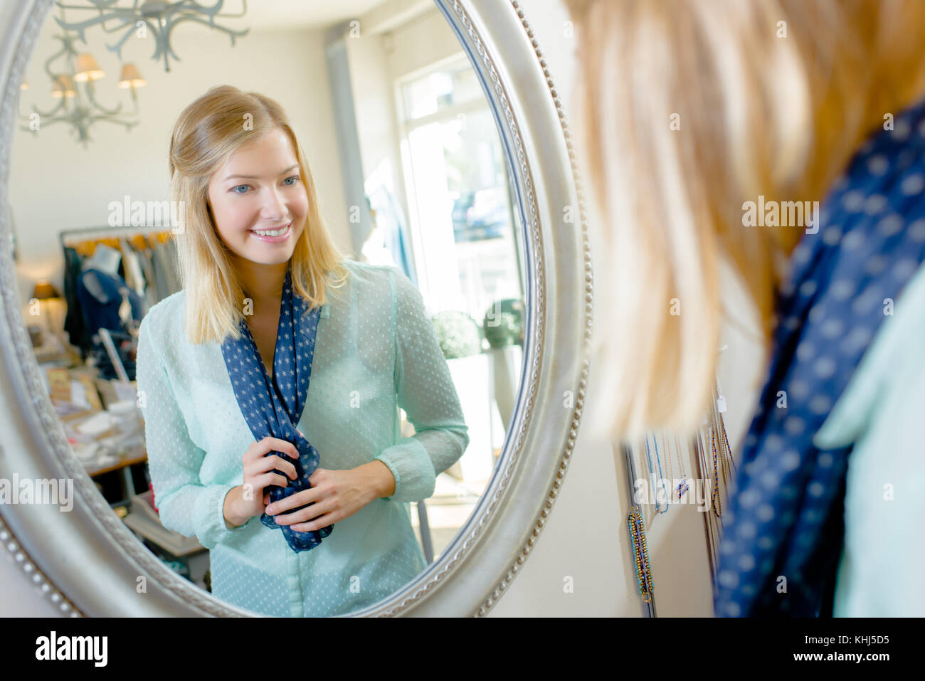 Woman looking her reflection in a mirror Stock Photo - Alamy