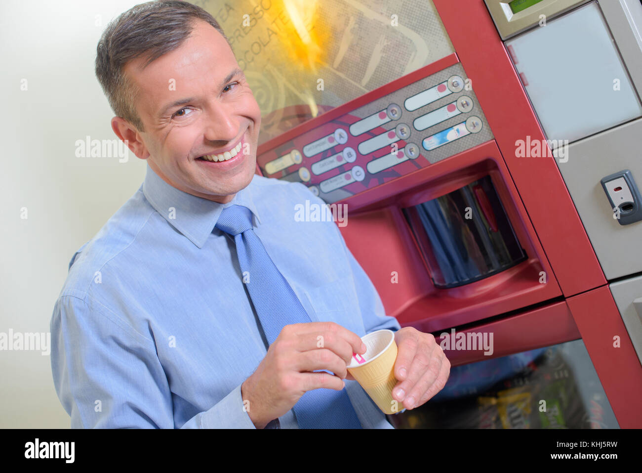 Man getting coffee from a vending machine Stock Photo - Alamy