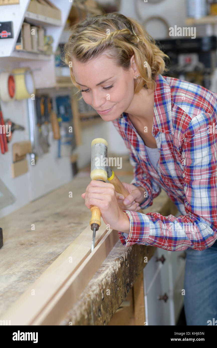 happy female carpenter carving wood Stock Photo - Alamy