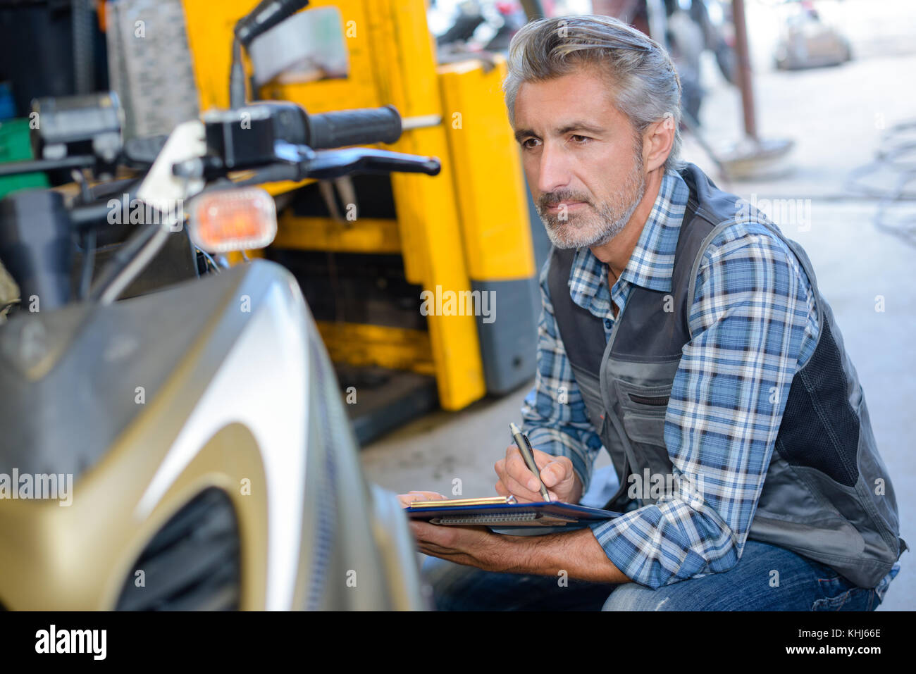 Mechanic assessing scooter Stock Photo - Alamy