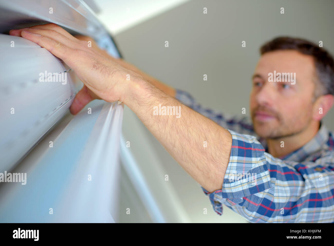 Handyman installing a window shutter Stock Photo - Alamy