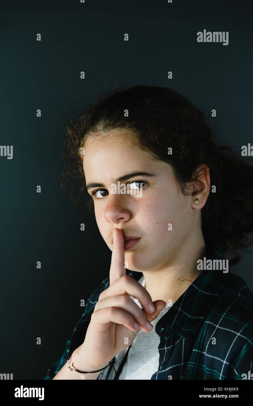 Defiant teenager with finger on lips Stock Photo - Alamy