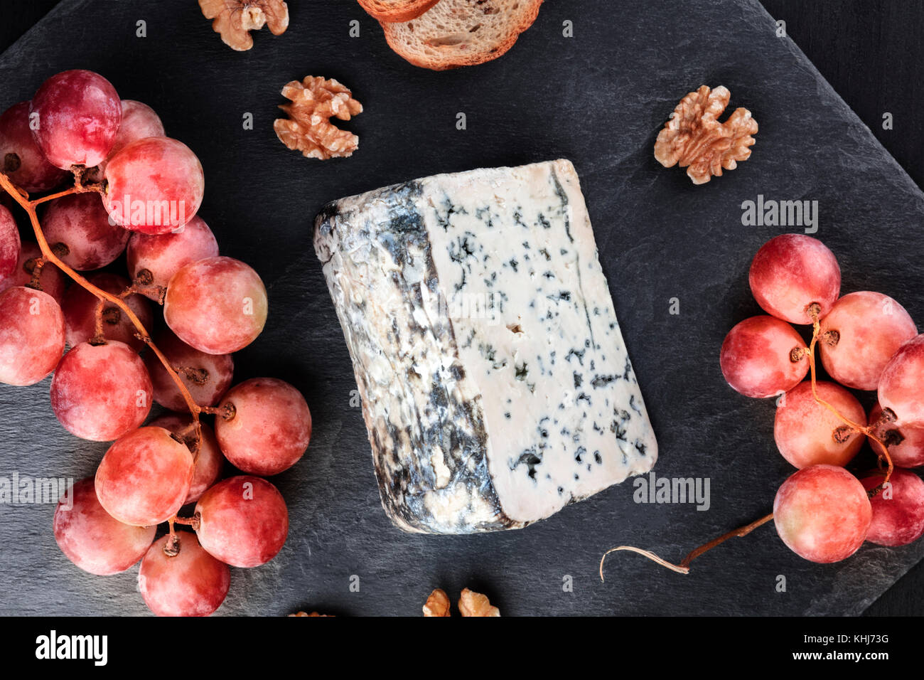 Blue cheese and vibrant grapes on black Stock Photo - Alamy