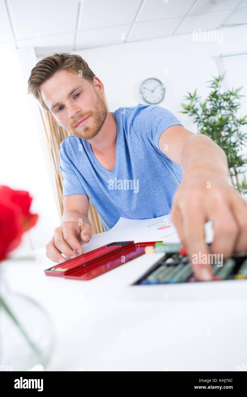young man drawing in coloring book Stock Photo - Alamy
