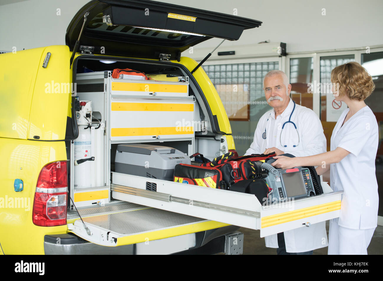 paramedics loading equipment into back of ambulance Stock Photo - Alamy