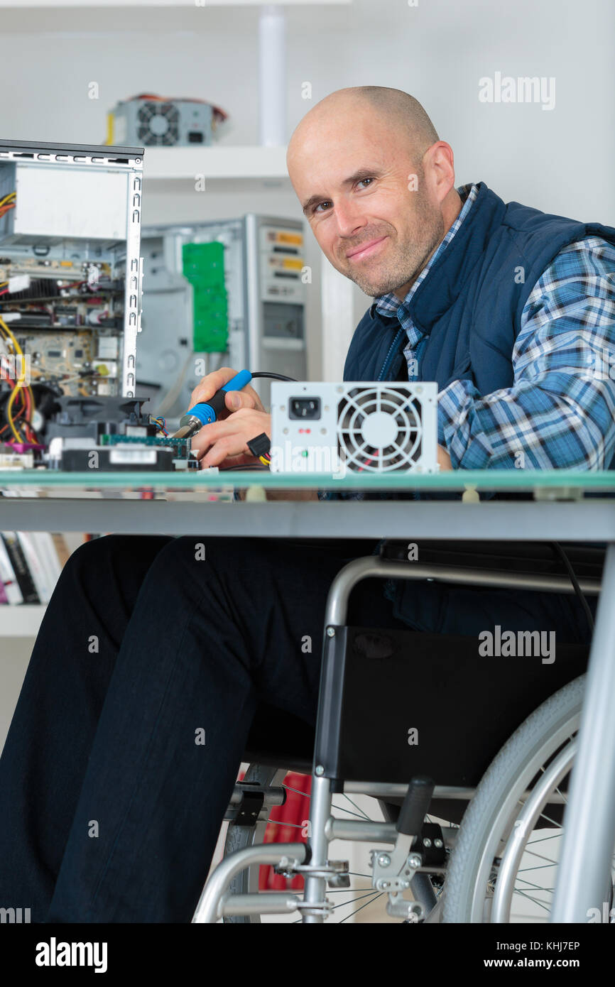 disabled worker in wheelchair fixing a computer Stock Photo - Alamy