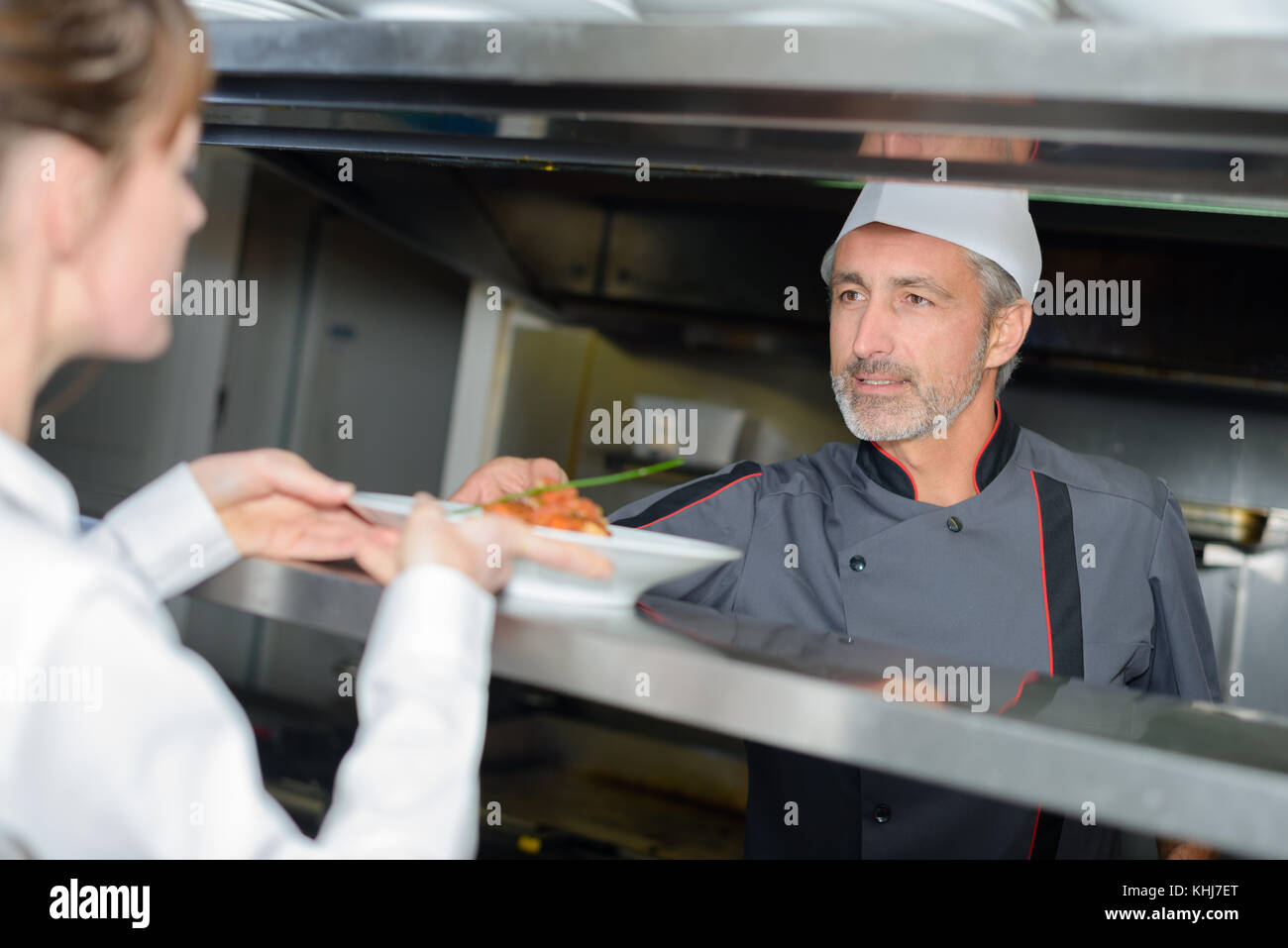 Chef putting plate on serving hatch Stock Photo - Alamy