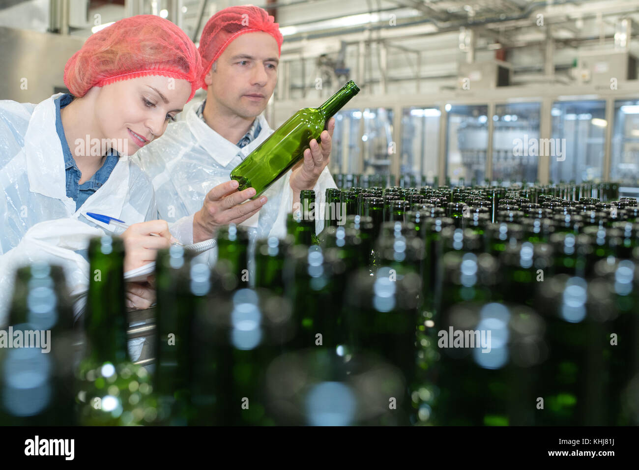 cheerful man and woman wearing uniform standing in brewery line Stock ...