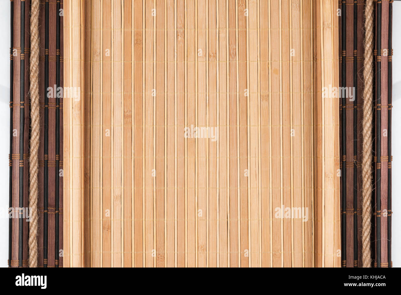 Bamboo mat with curled edges and rope, on white background. Space for ...