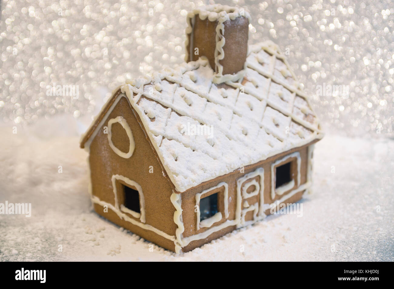 Gingerbread house in winter lights covered with icing sugar and ...