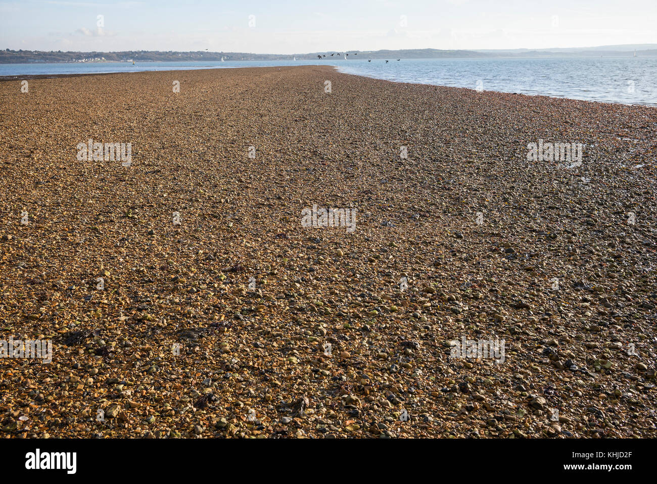 A shingle bar extending into the sea at low tide over looking The ...