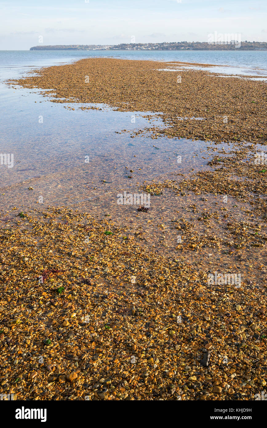 A shingle bar extending into the sea at low tide over looking The ...