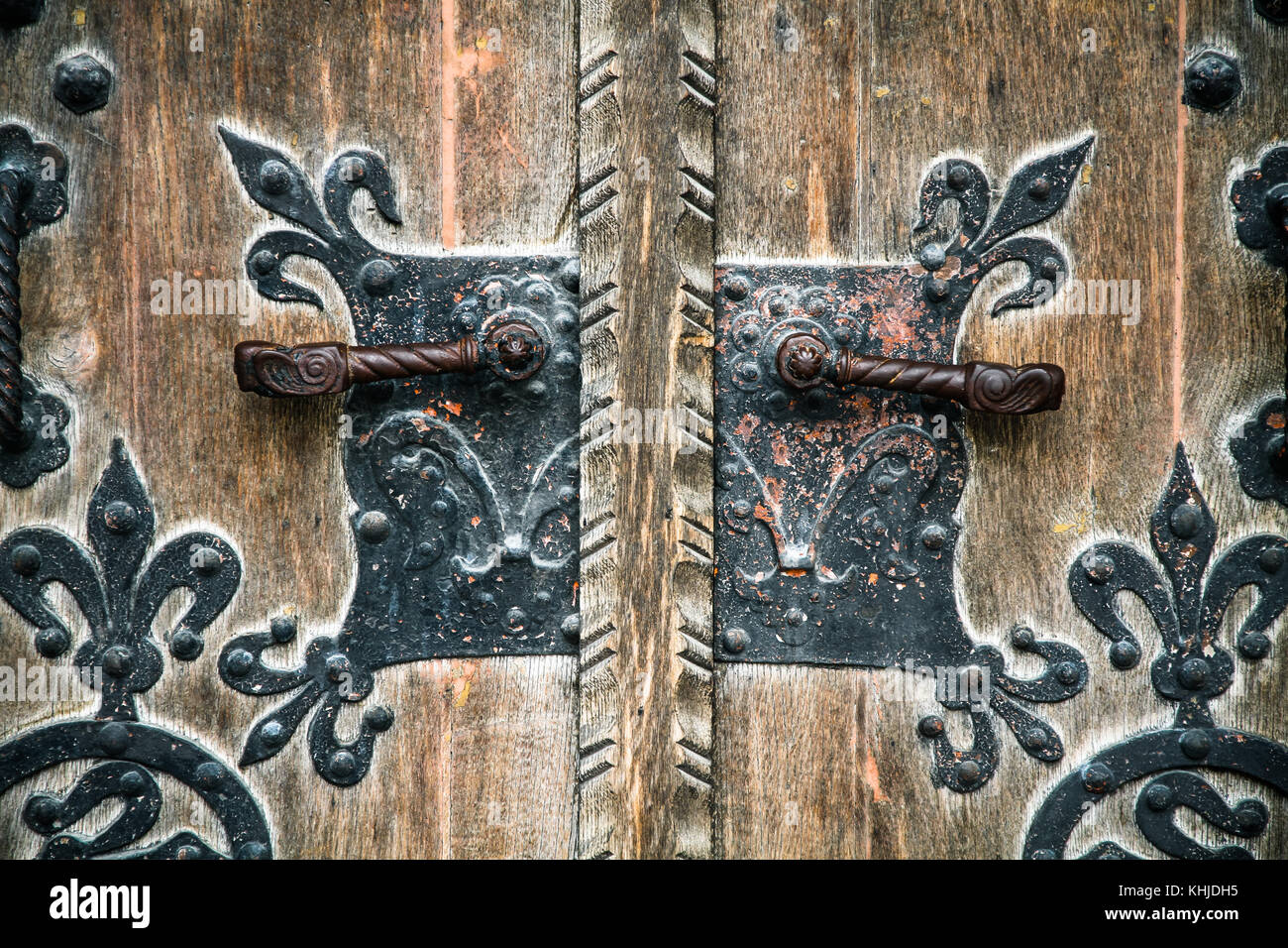 Medieval old vintage and rusted black iron door handle installed on an ...