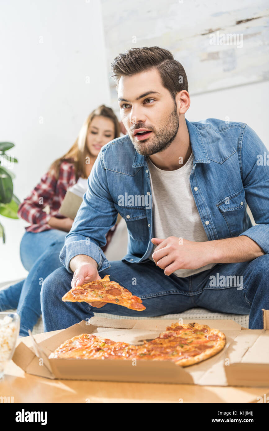Man holding slice of pizza Stock Photo - Alamy